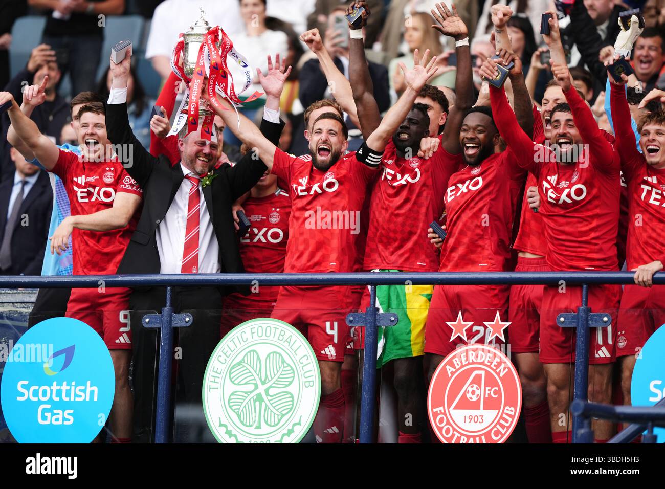 Aberdeen's Graeme Shinnie (centre) lifts the trophy after winning the ...