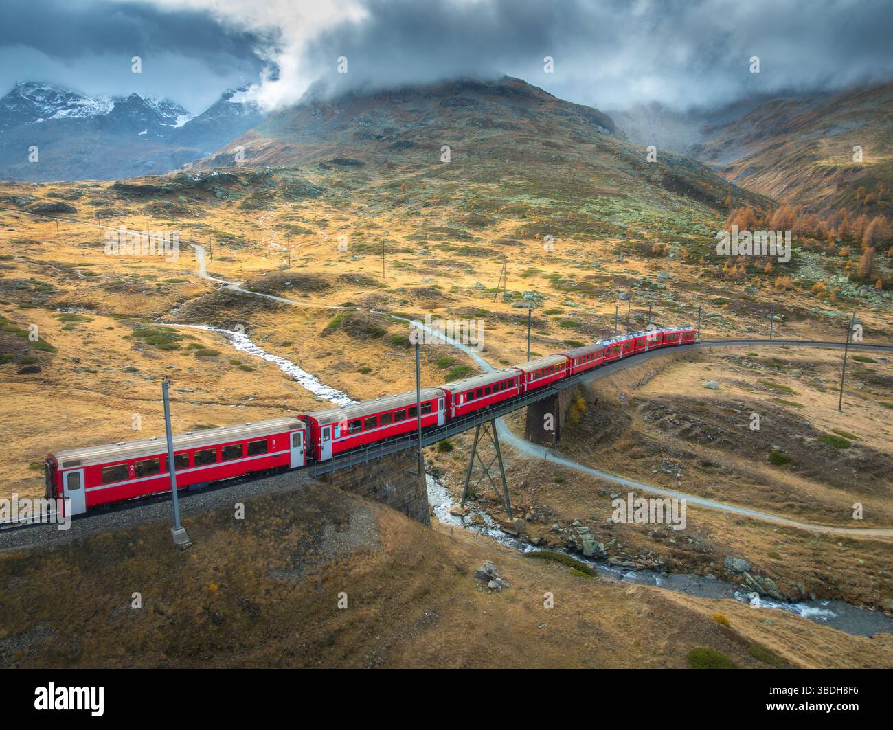Aerial view of red train is moving through bridges in swiss alps Stock ...