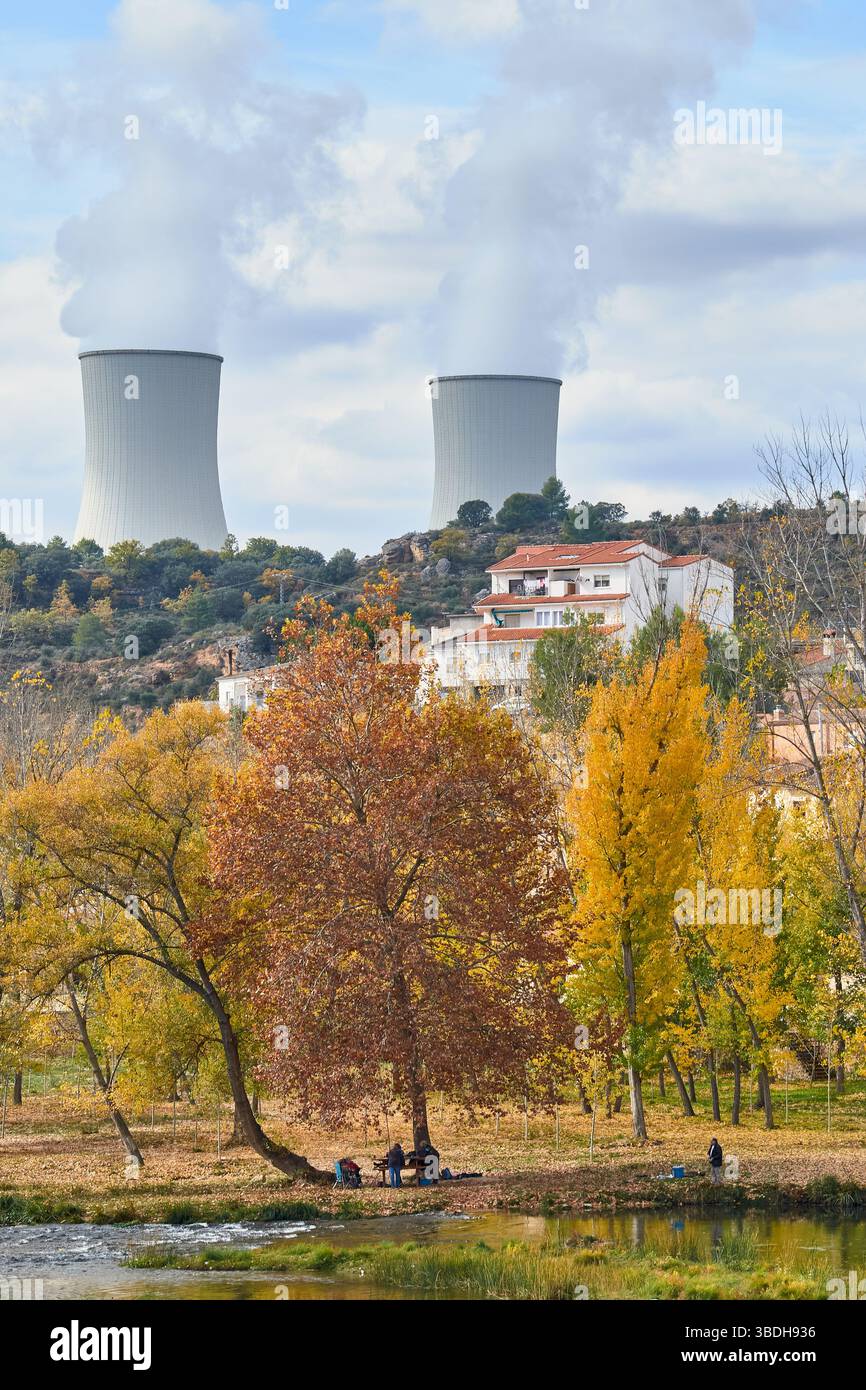 Chimneys of a nuclear power plant near a river and trees on the banks ...