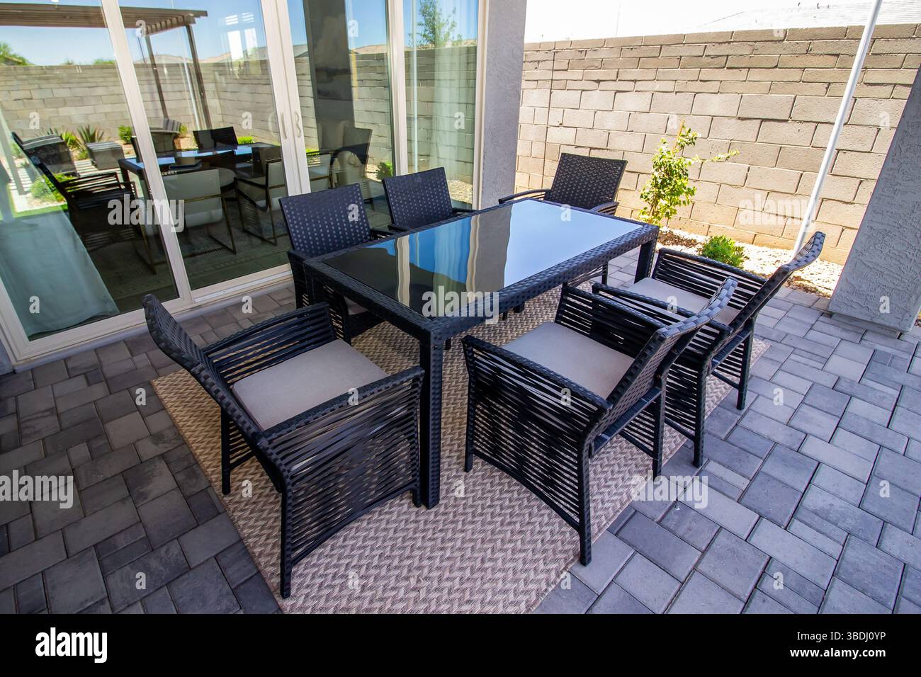 Rattan Patio Furniture And Table On Rear Pavers Patio Stock Photo - Alamy