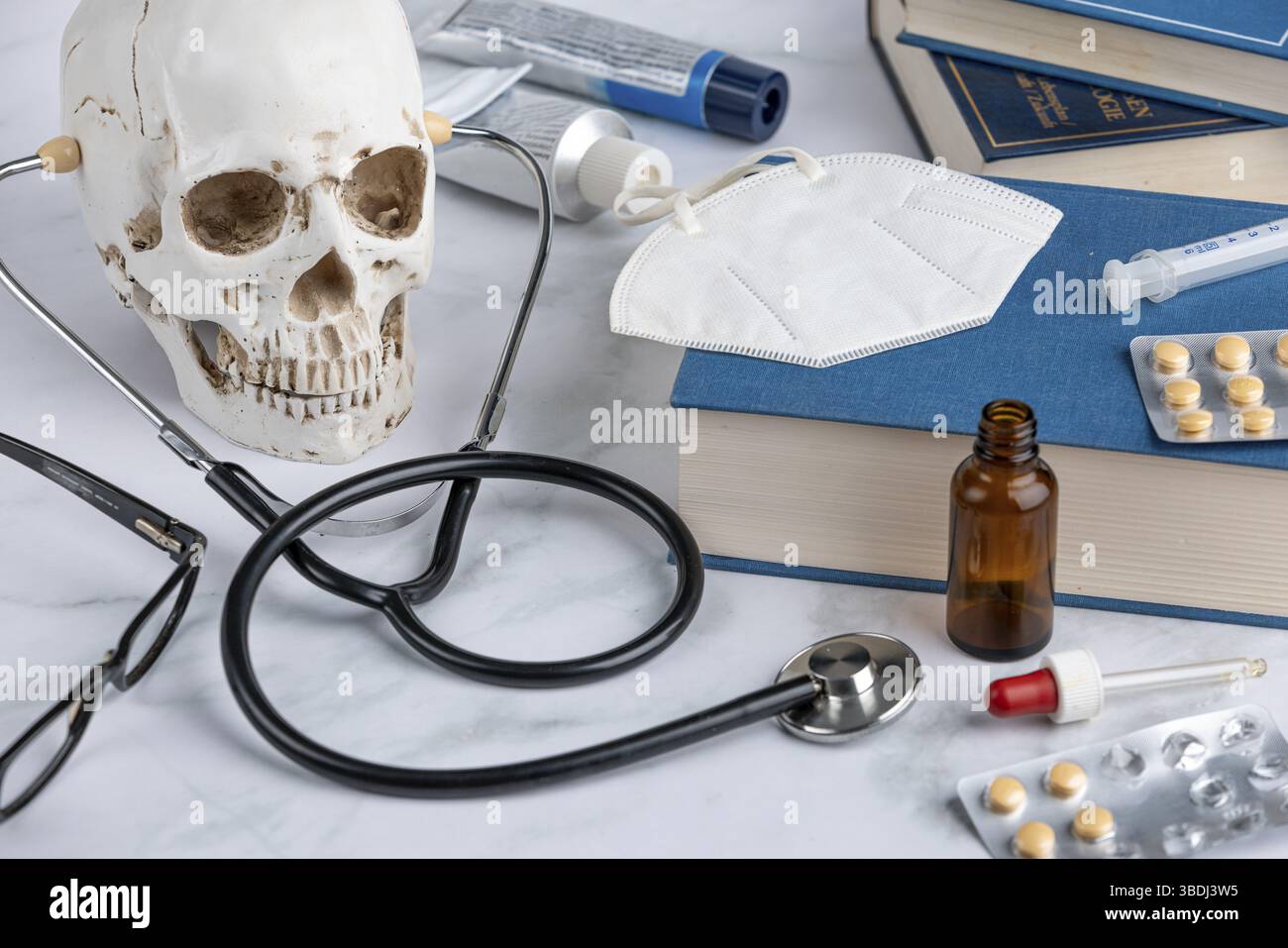 Skull with stethoscope surrounded by face mask, tablets and medical ...
