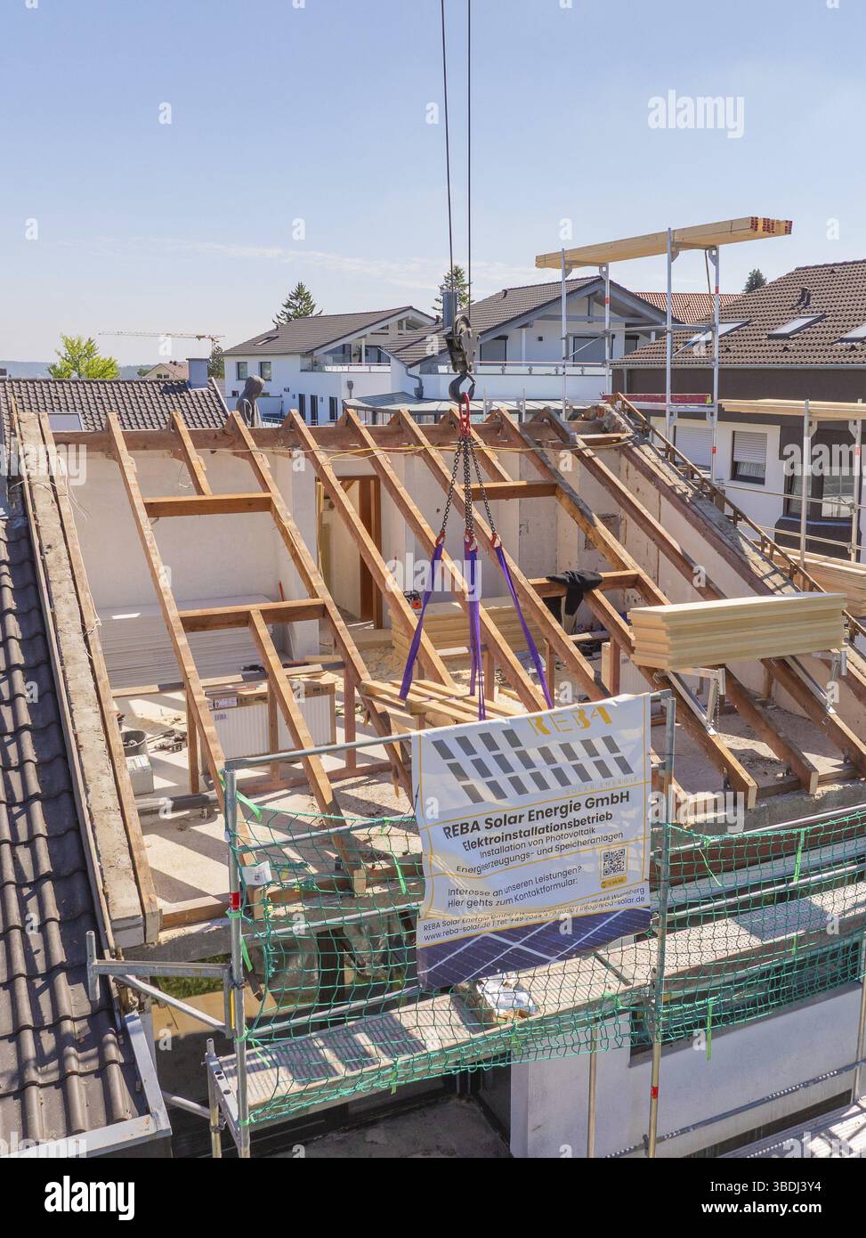 Building with roof renovation and crane, surrounded by other houses ...