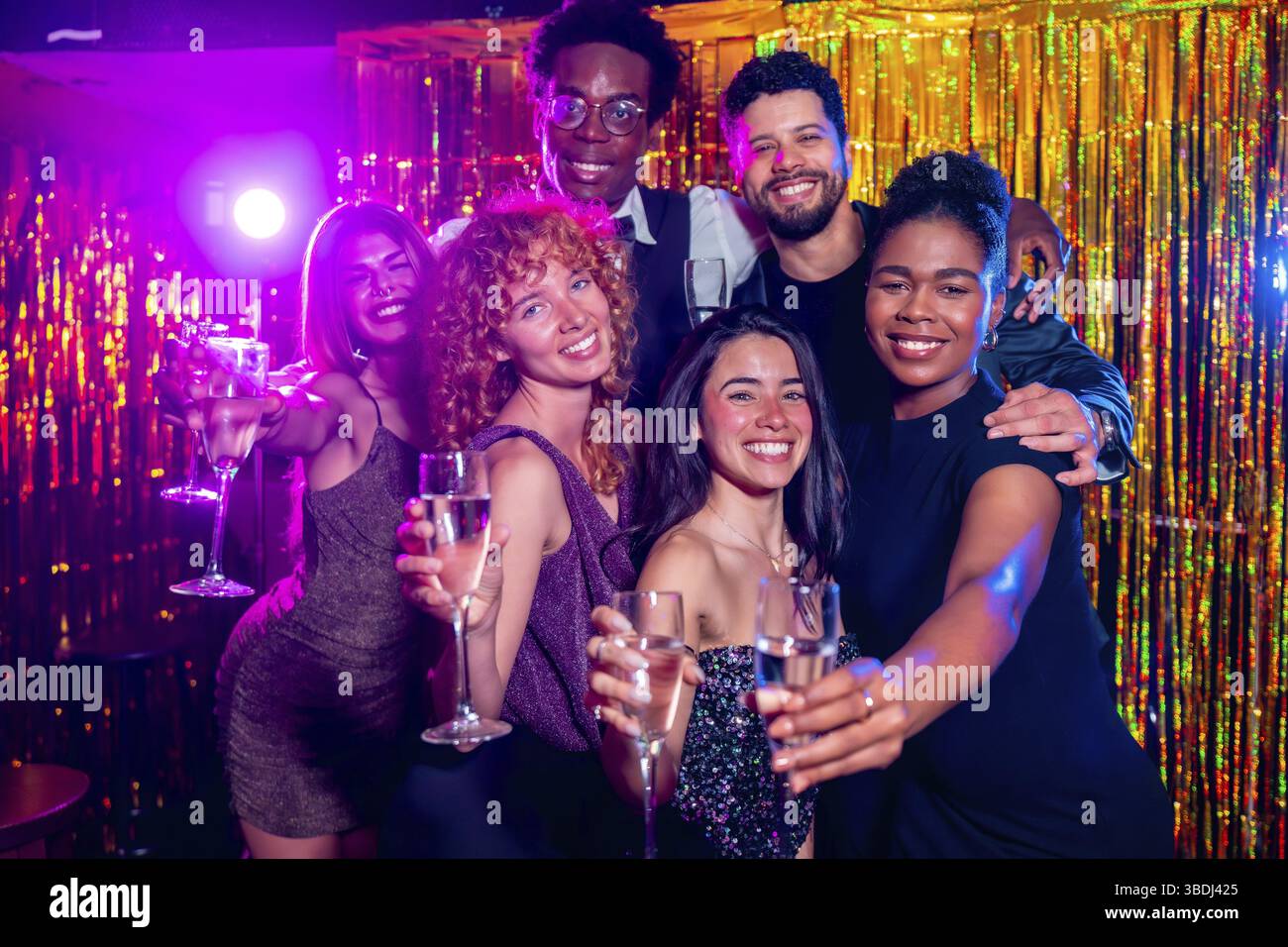 Group of cheerful elegant friends toasting champagne flutes, enjoying ...