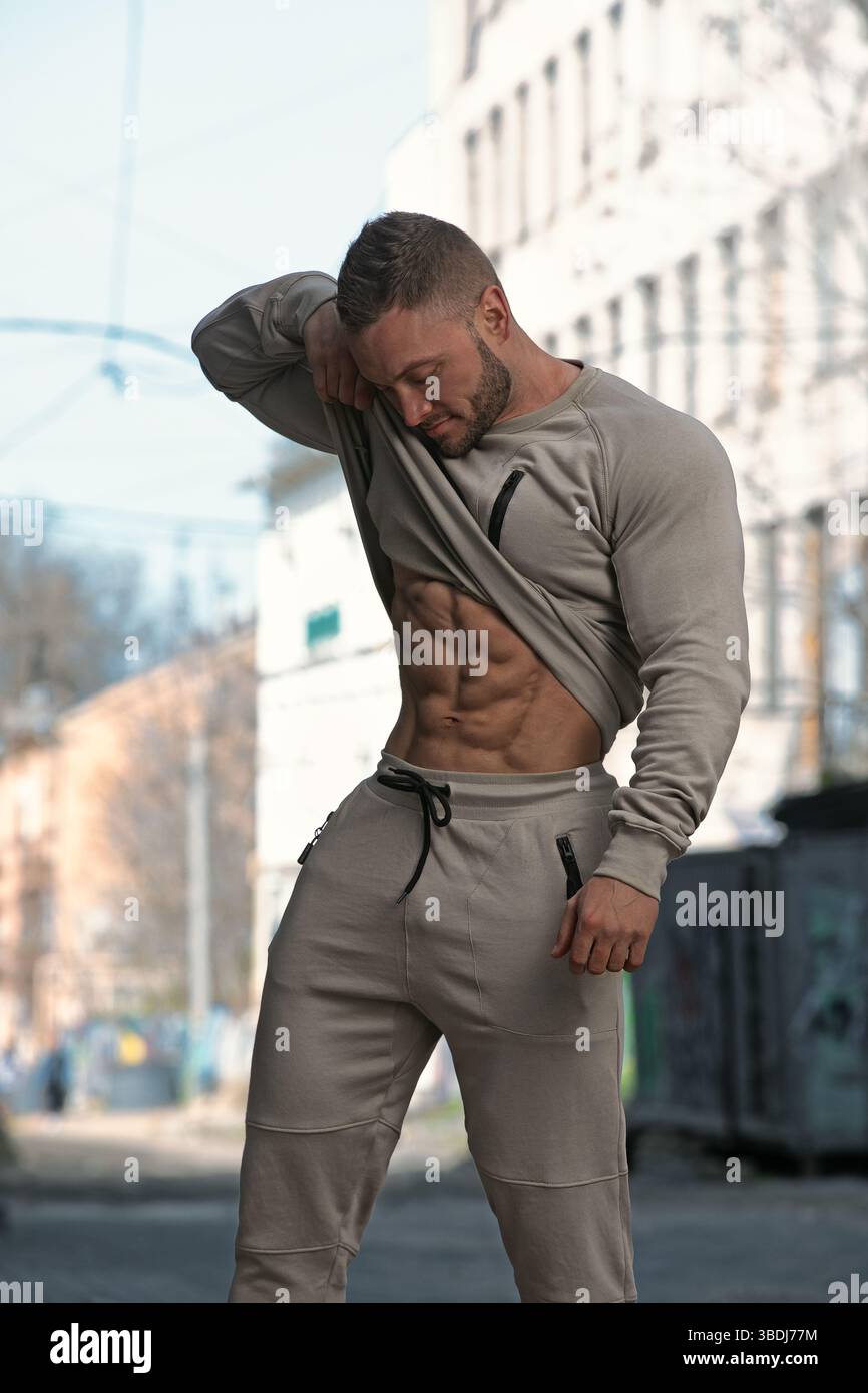 fitness enthusiast showcases a well defined physique in an urban ...