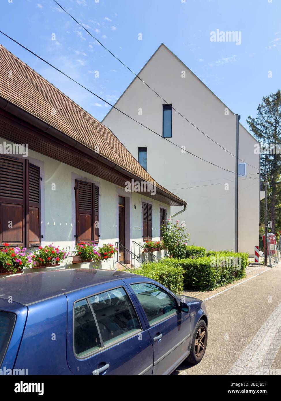 A traditional house with flower boxes and wooden shutters stands beside ...