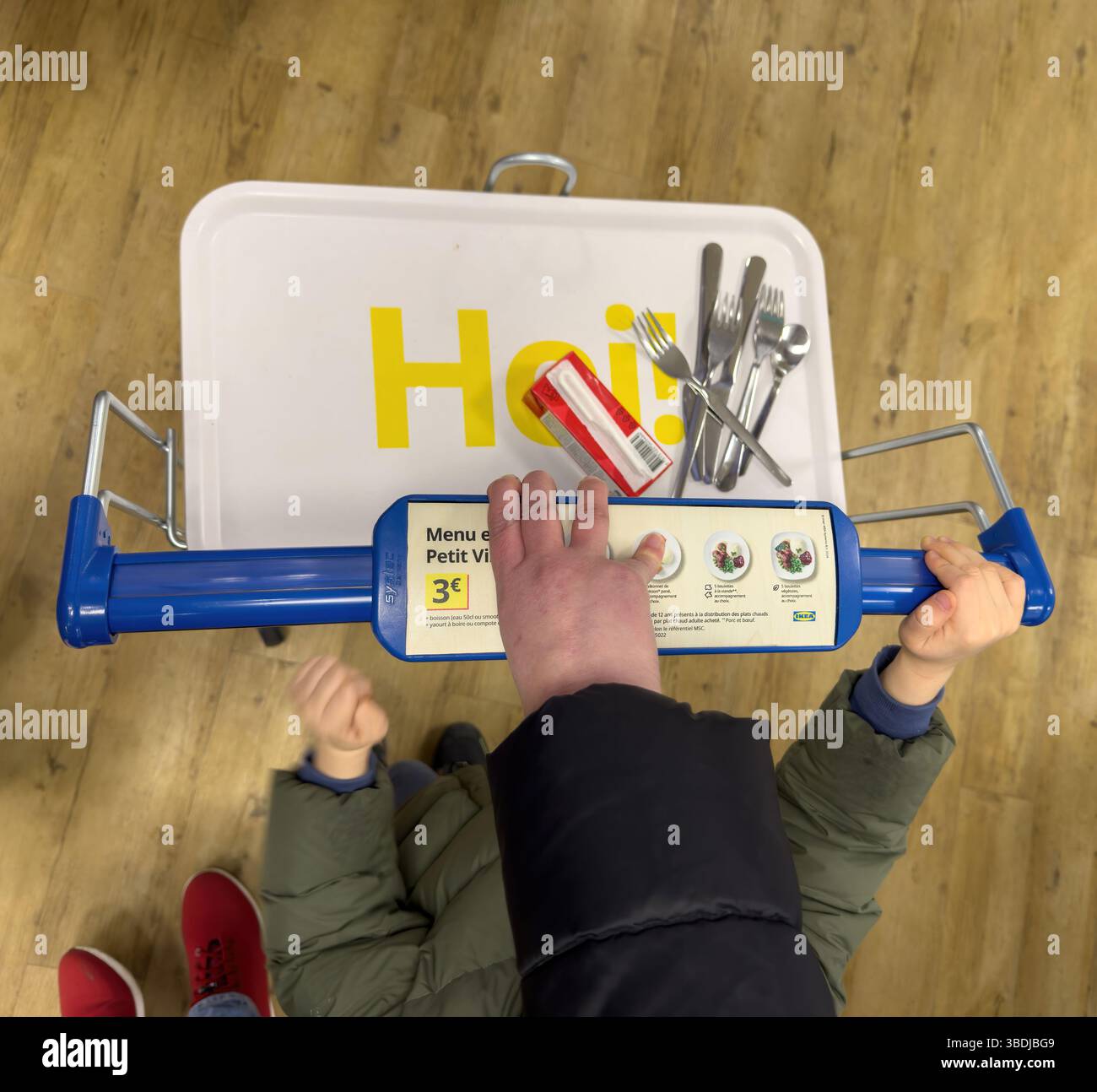 Paris, France - Mar 15, 2025: An adult and a child push a blue-handled ...