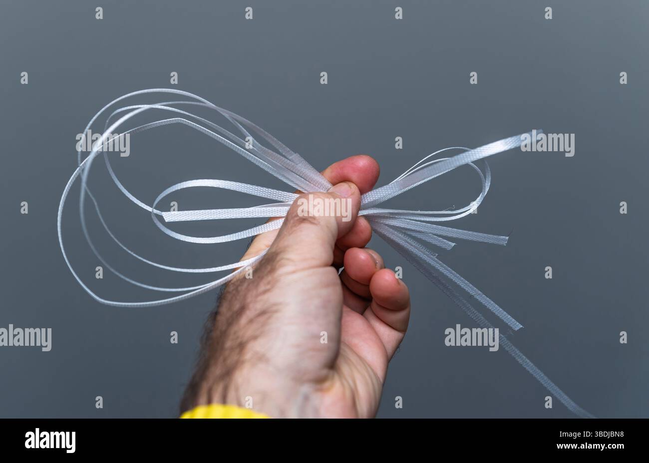 A close-up view of a hand tightly gripping several translucent white ...