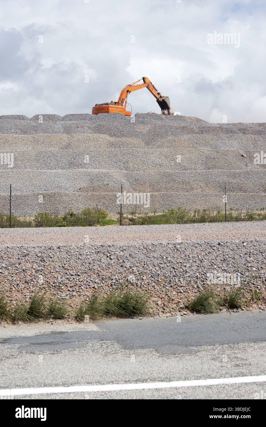 A big digging machine loads gravel in to a truck at road works Stock ...