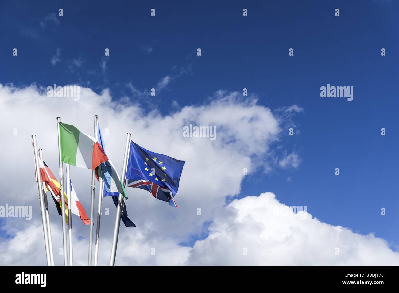 Horizontal view of different flags of the European Union in a blue sky ...