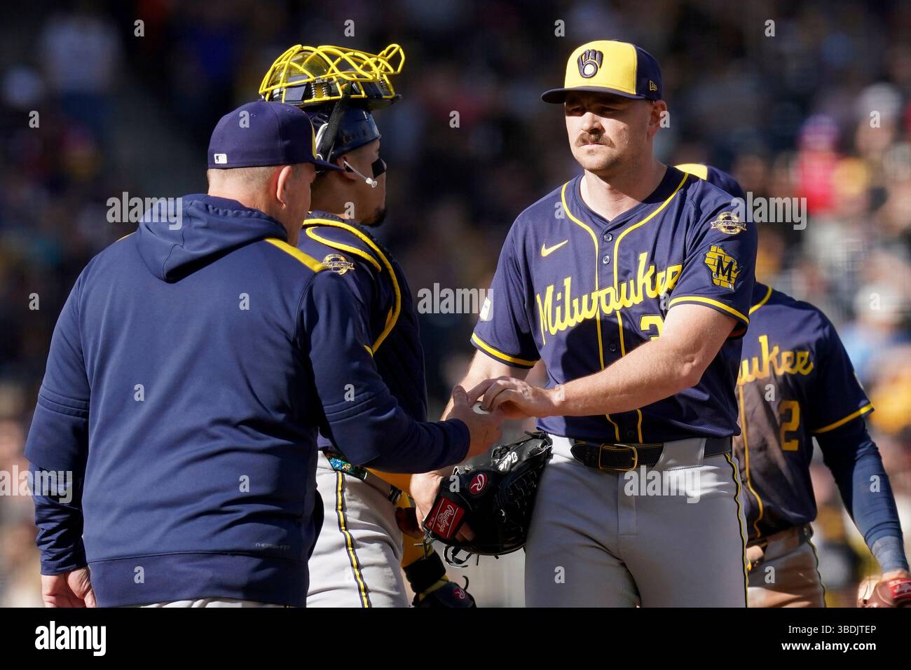 Milwaukee Brewers pitcher Tyler Alexander, right, hands the ball to ...