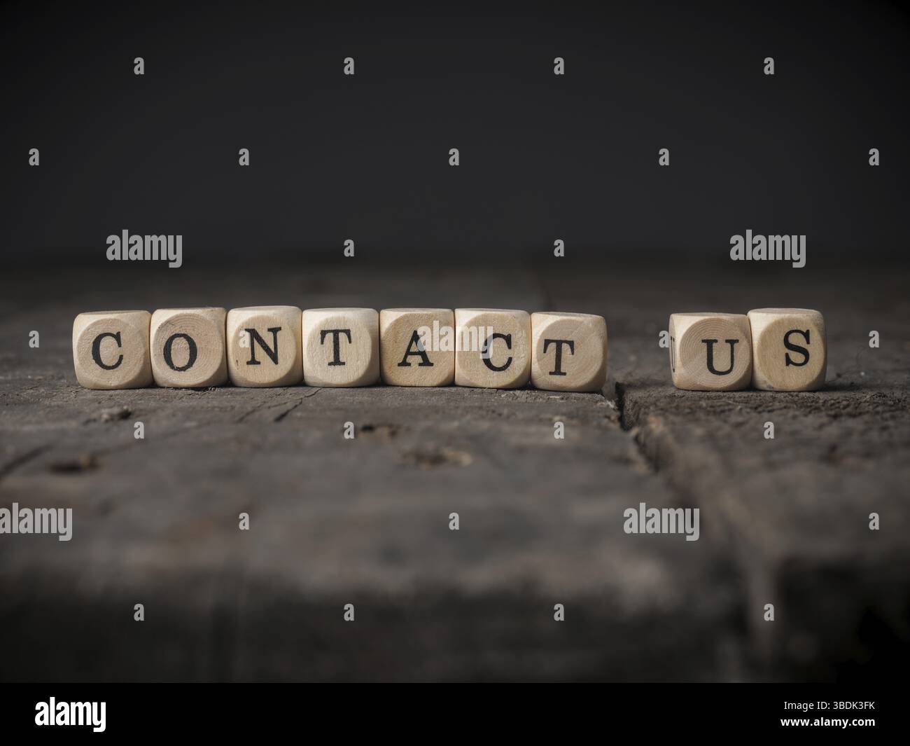Small wooden dices with the words Contact us on a table Stock Photo - Alamy