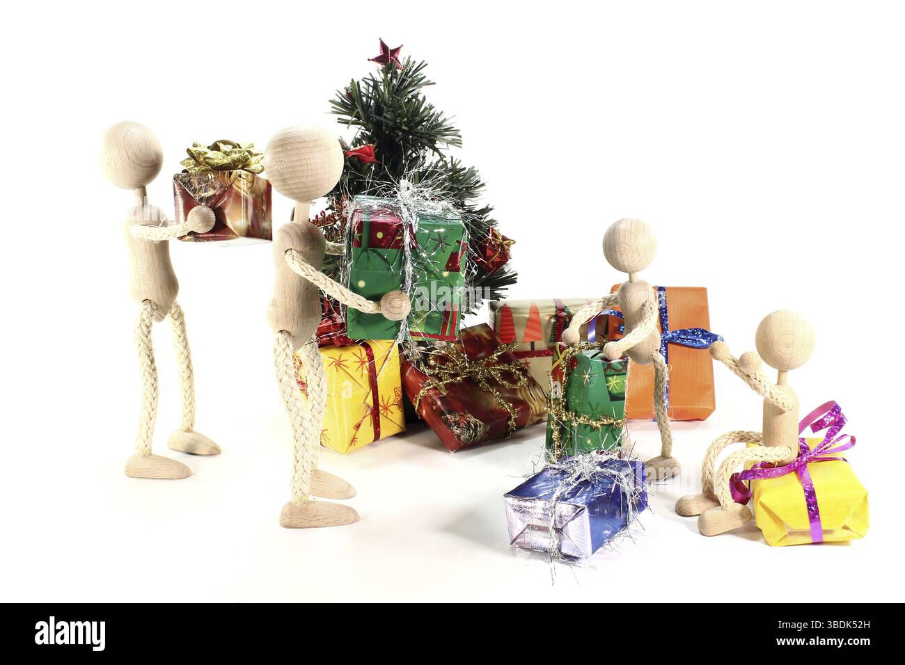 Wooden dolls giving presents with a Christmas tree and lots of ...