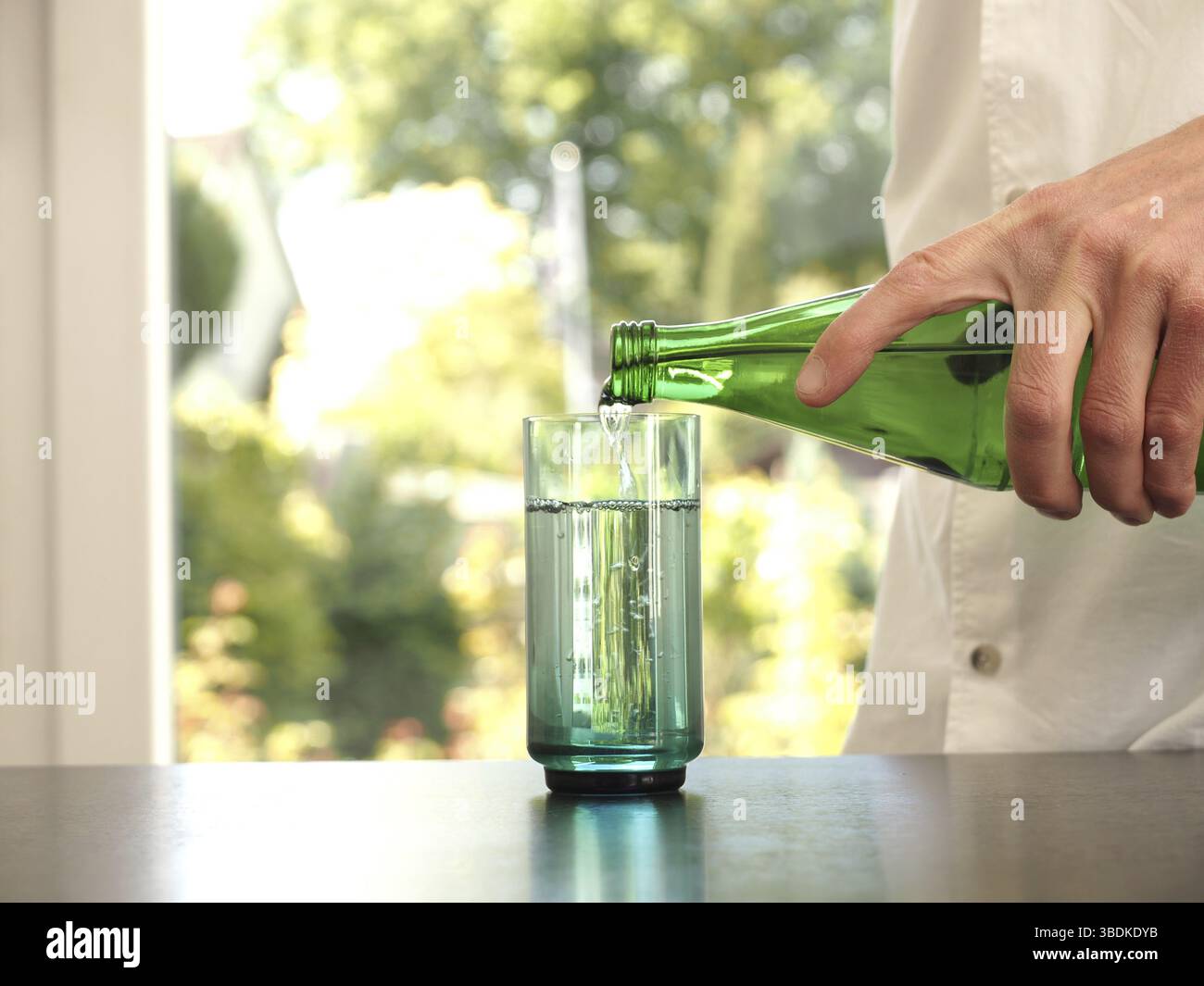 Mid aged man pouring water into a glass, healthy eating concept, clean and fresh Stock Photo - Alamy