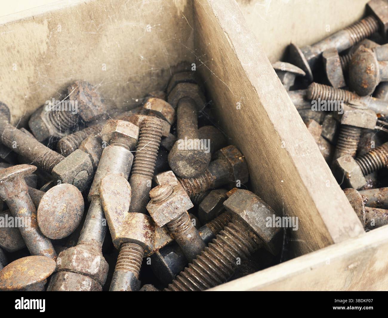 Old rusty bolts and nuts in a wooden box, industrial concept background ...