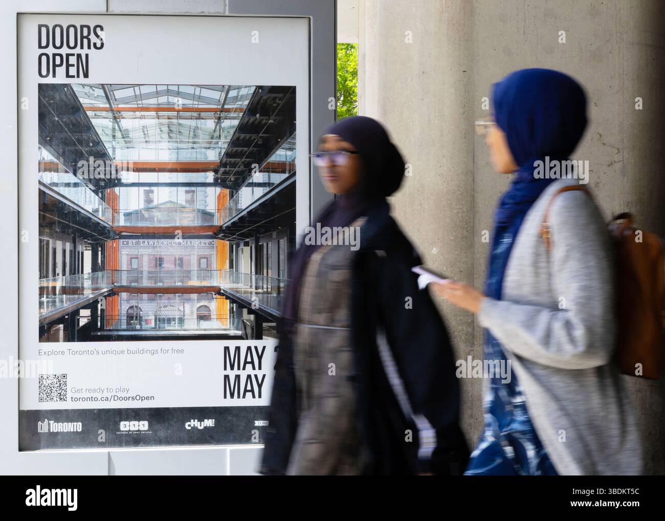 Toronto, Canada. 24th May, 2025. People walk past a 2025 Doors Open ...