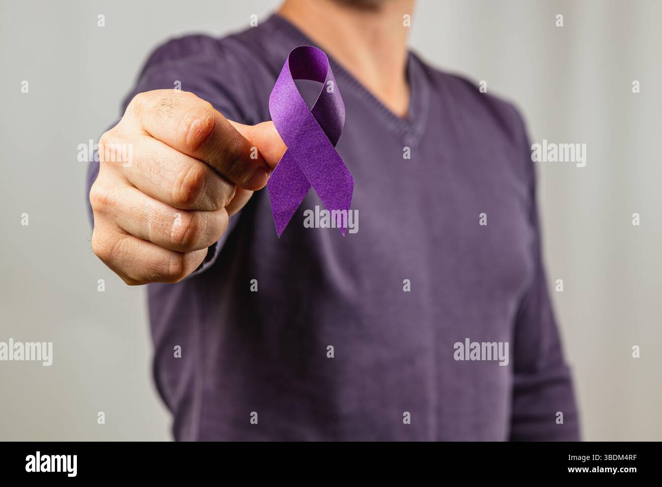 A man stands against a neutral background, confidently presenting a ...