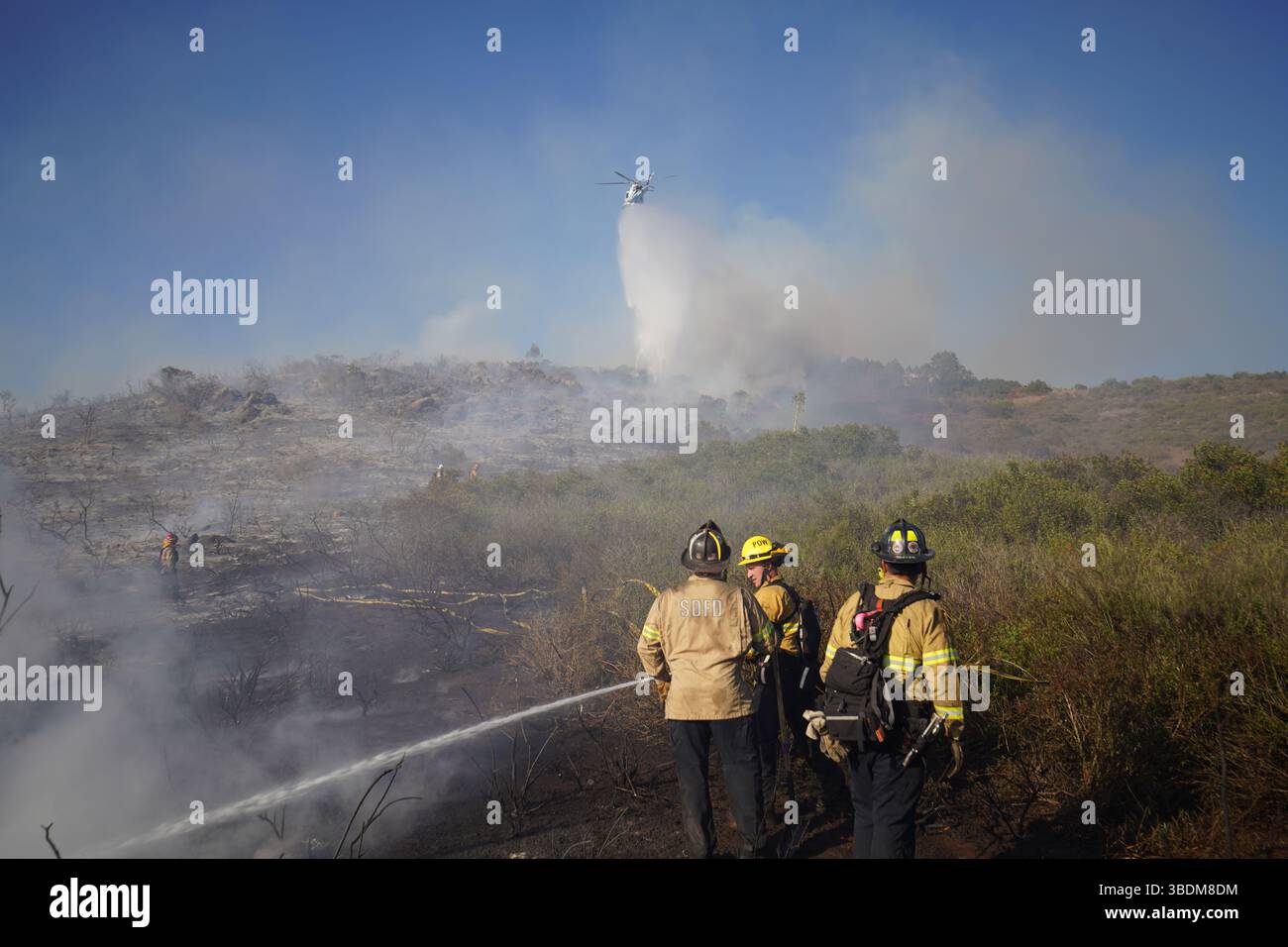 Firefighters contain the fire on the mountains while helicopter drop ...