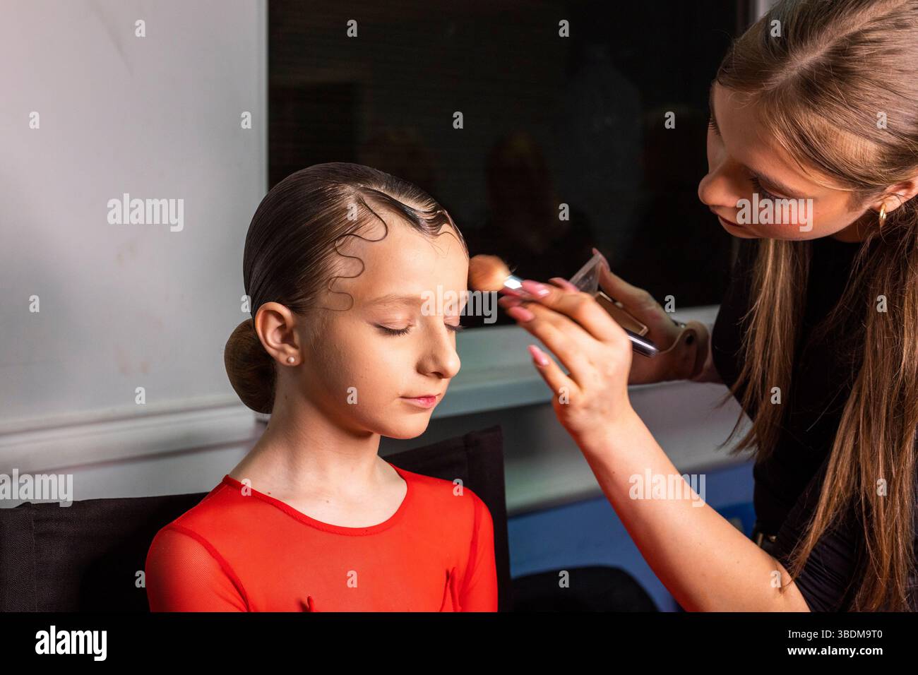 master creates professional makeup for a girl in ballroom dancing ...