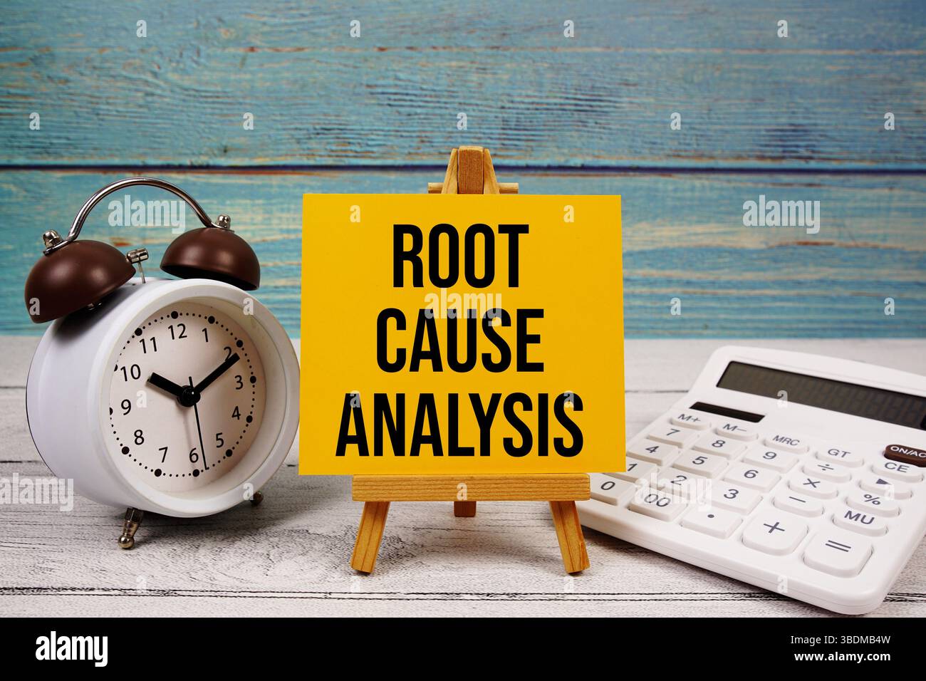 Root Cause Analysis (RCA) text written on paper card with calculator and alarm clock on wooden ...