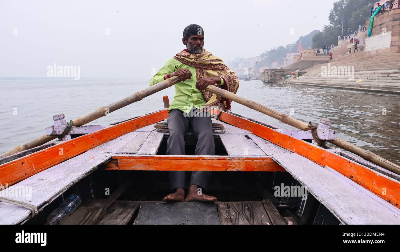 India, Uttar Pradesh, Varanasi, Man Riding a Traditional Boat in River ...