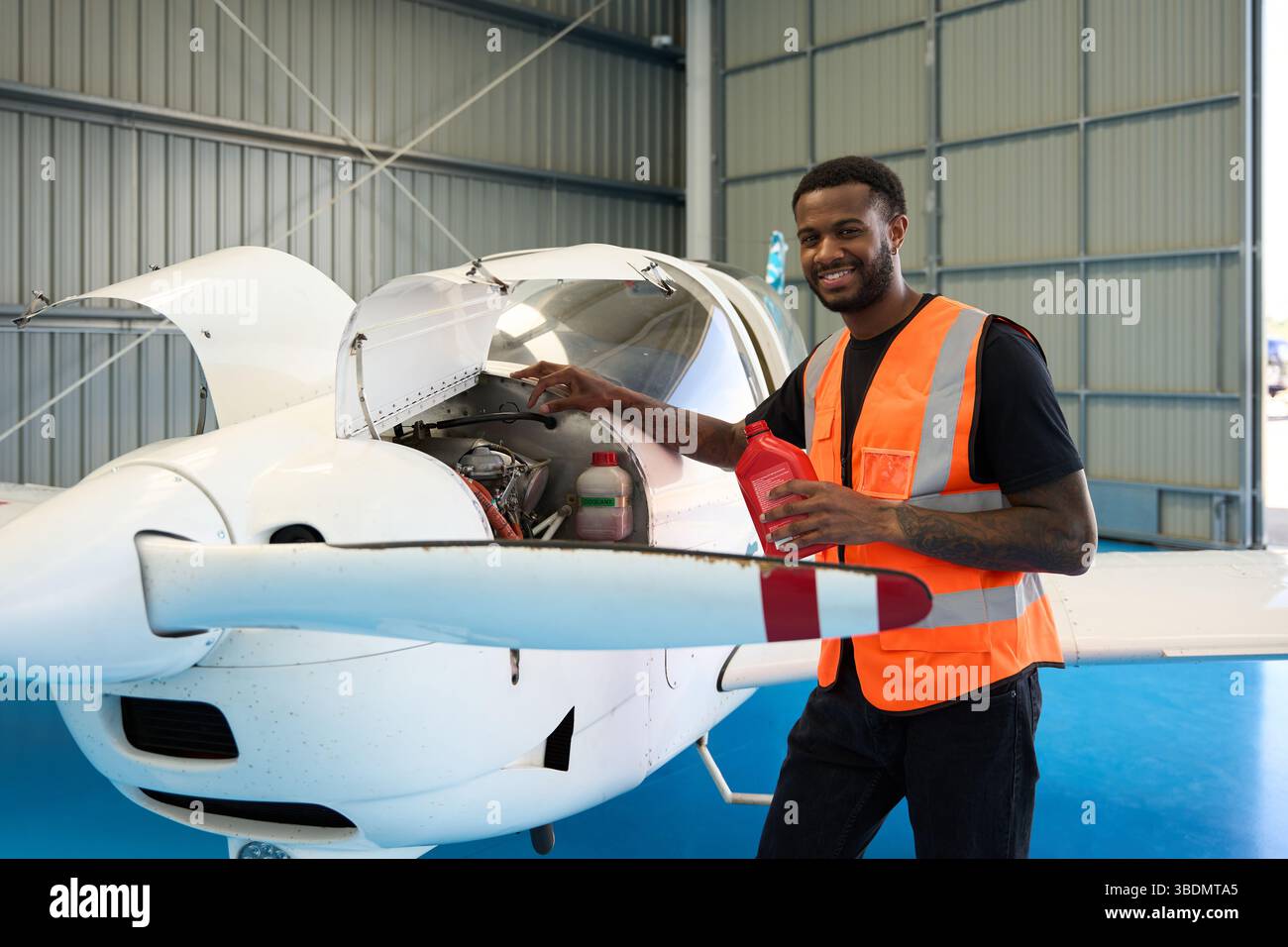 Aircraft mechanic performing maintenance on small airplane engine in ...