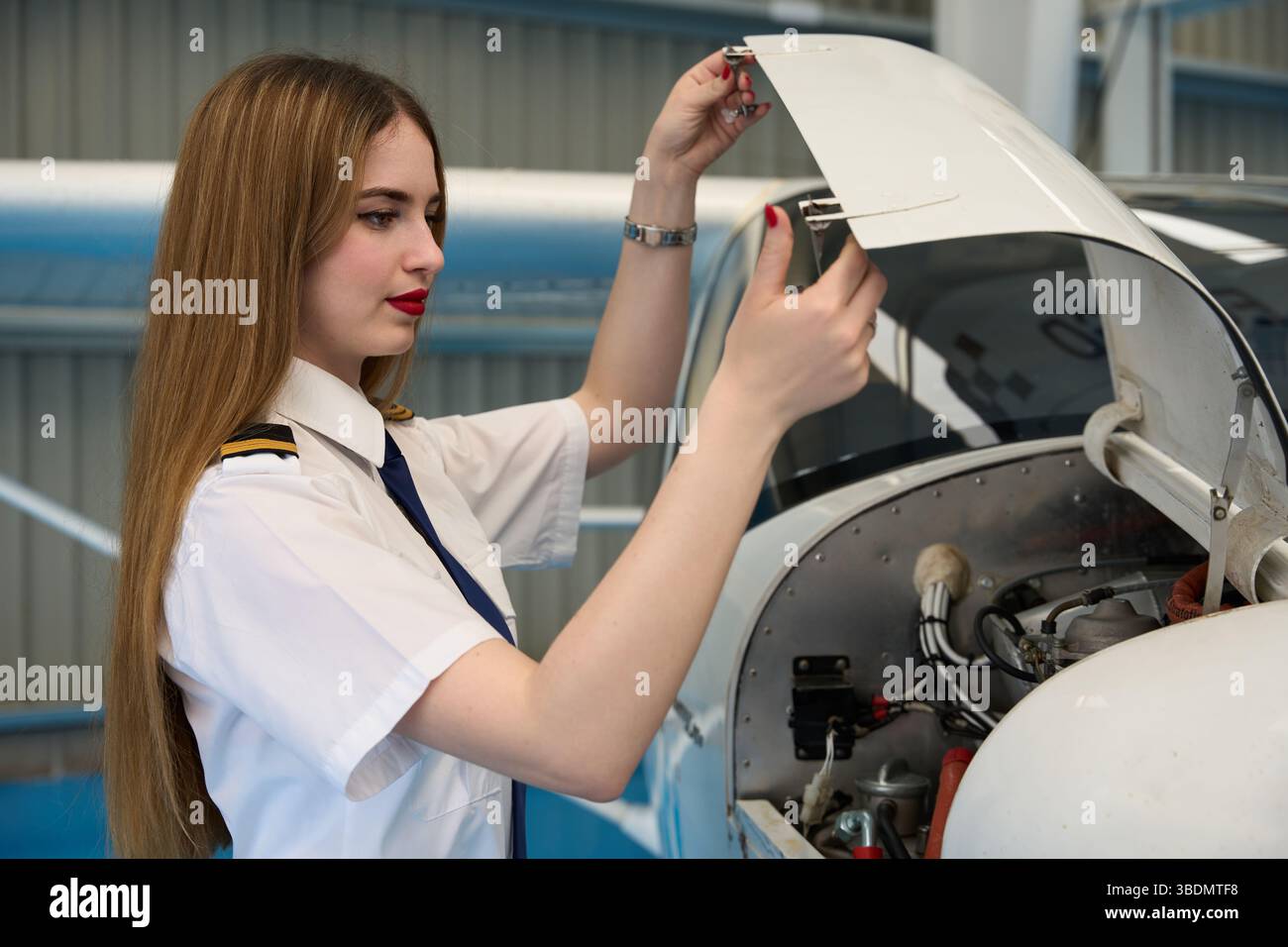Aircraft mechanic inspecting engine cowling in hangar Stock Photo - Alamy