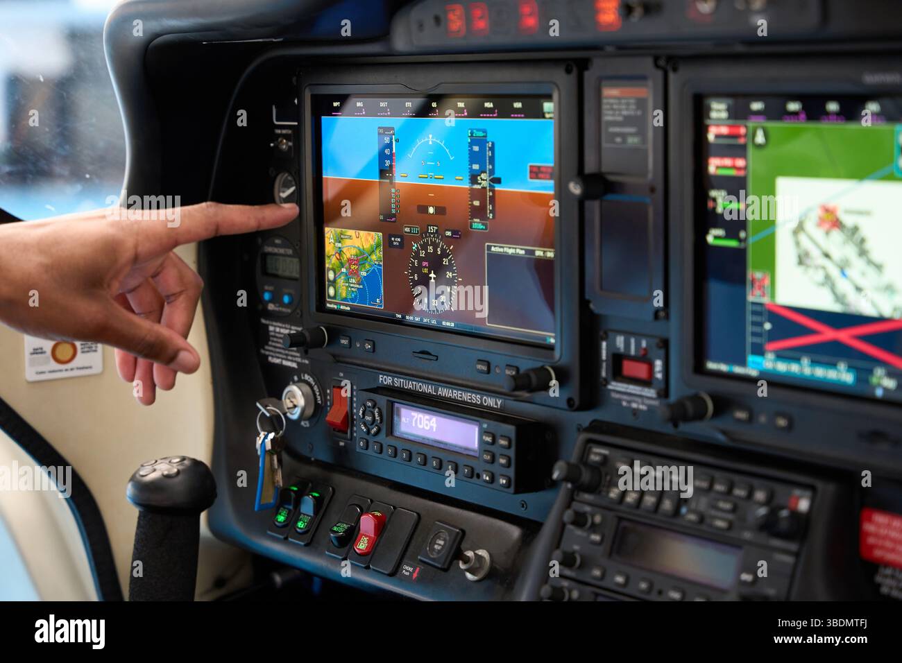 Pilot using touch screen in airplane cockpit during flight training ...