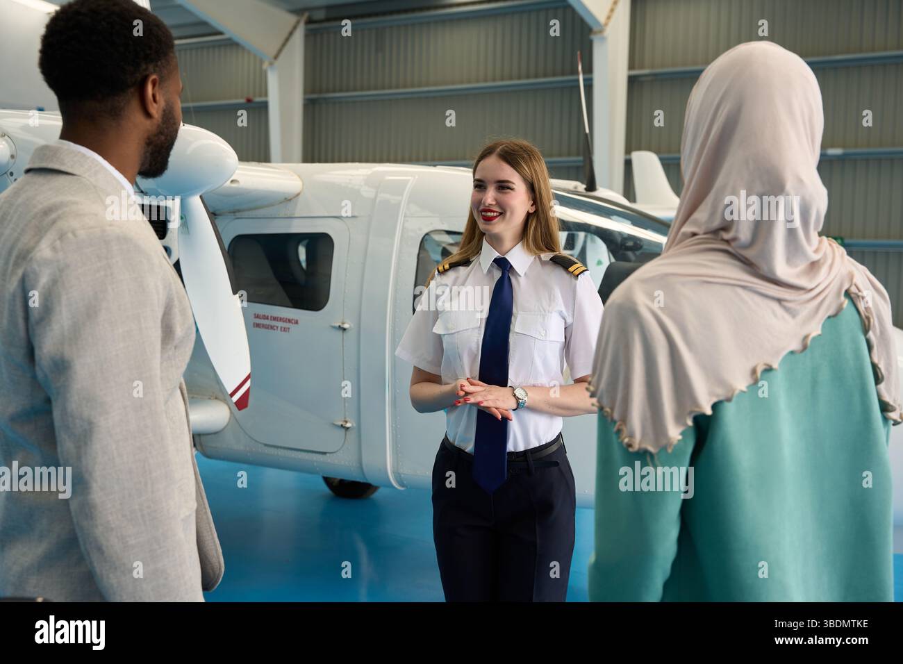 Female pilot talking to students in aircraft maintenance hangar Stock ...