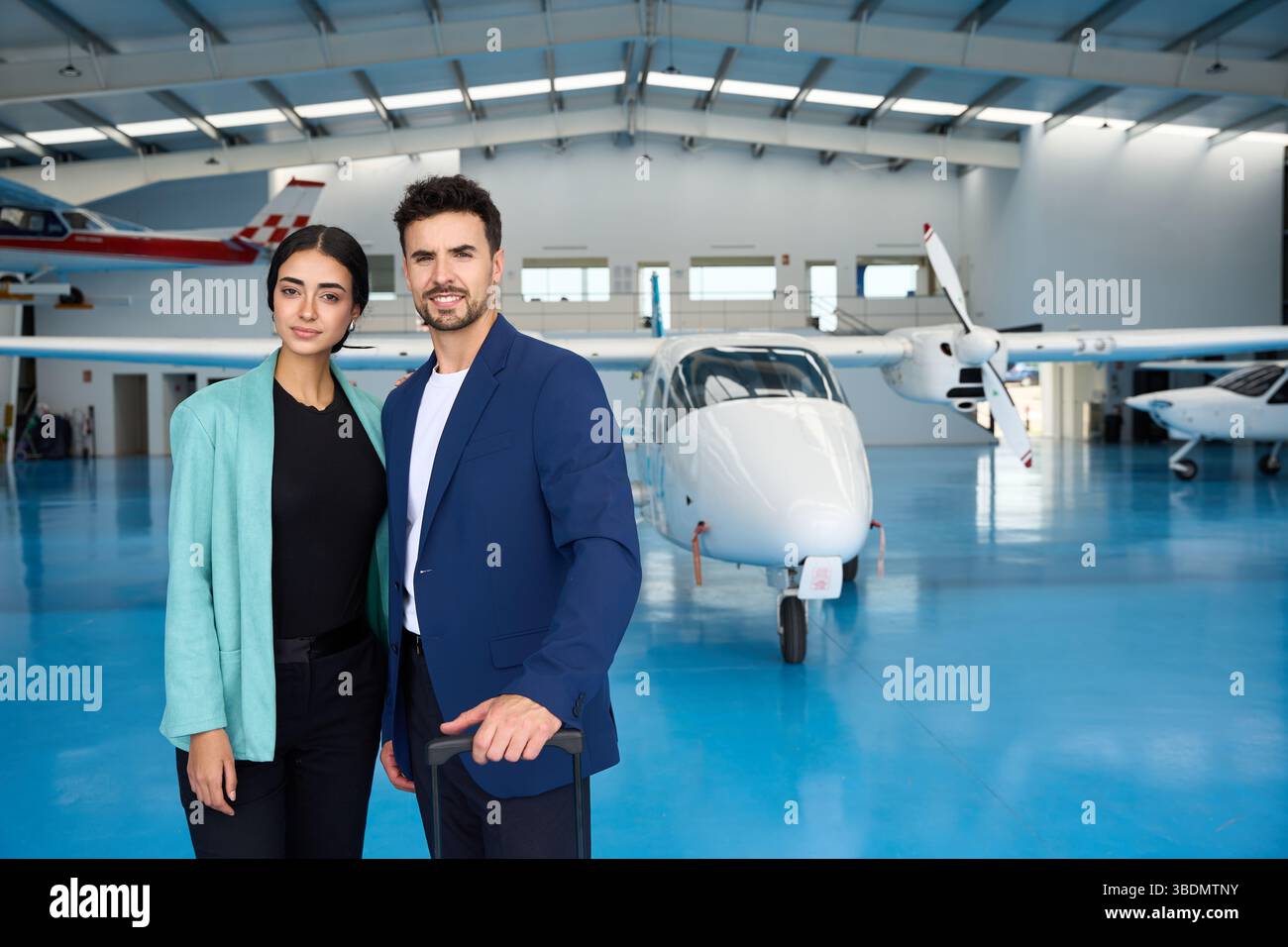 Flight school students posing with airplane in hangar Stock Photo - Alamy