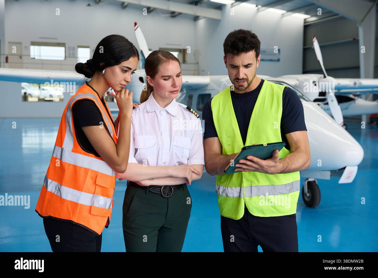 Aircraft maintenance team reviewing flight data in hangar Stock Photo ...