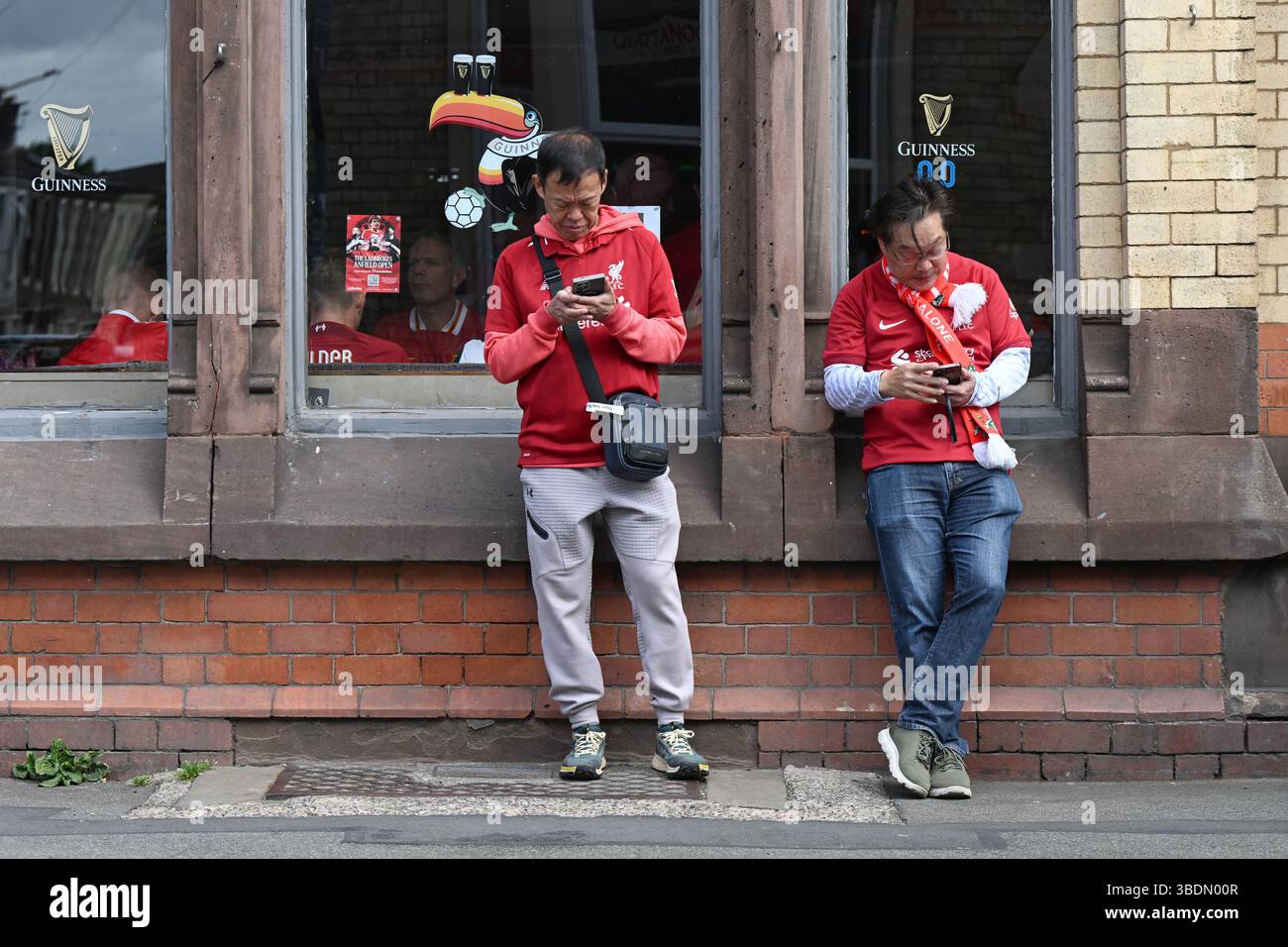 Liverpool fans looking at their phones before the Premier League match ...