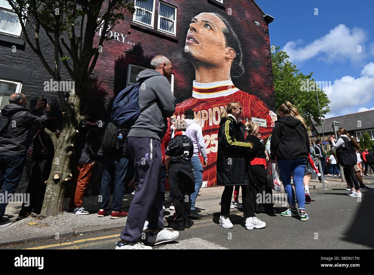 Liverpool fans walk past a mural of Liverpool captain Virgil van Dijk ...
