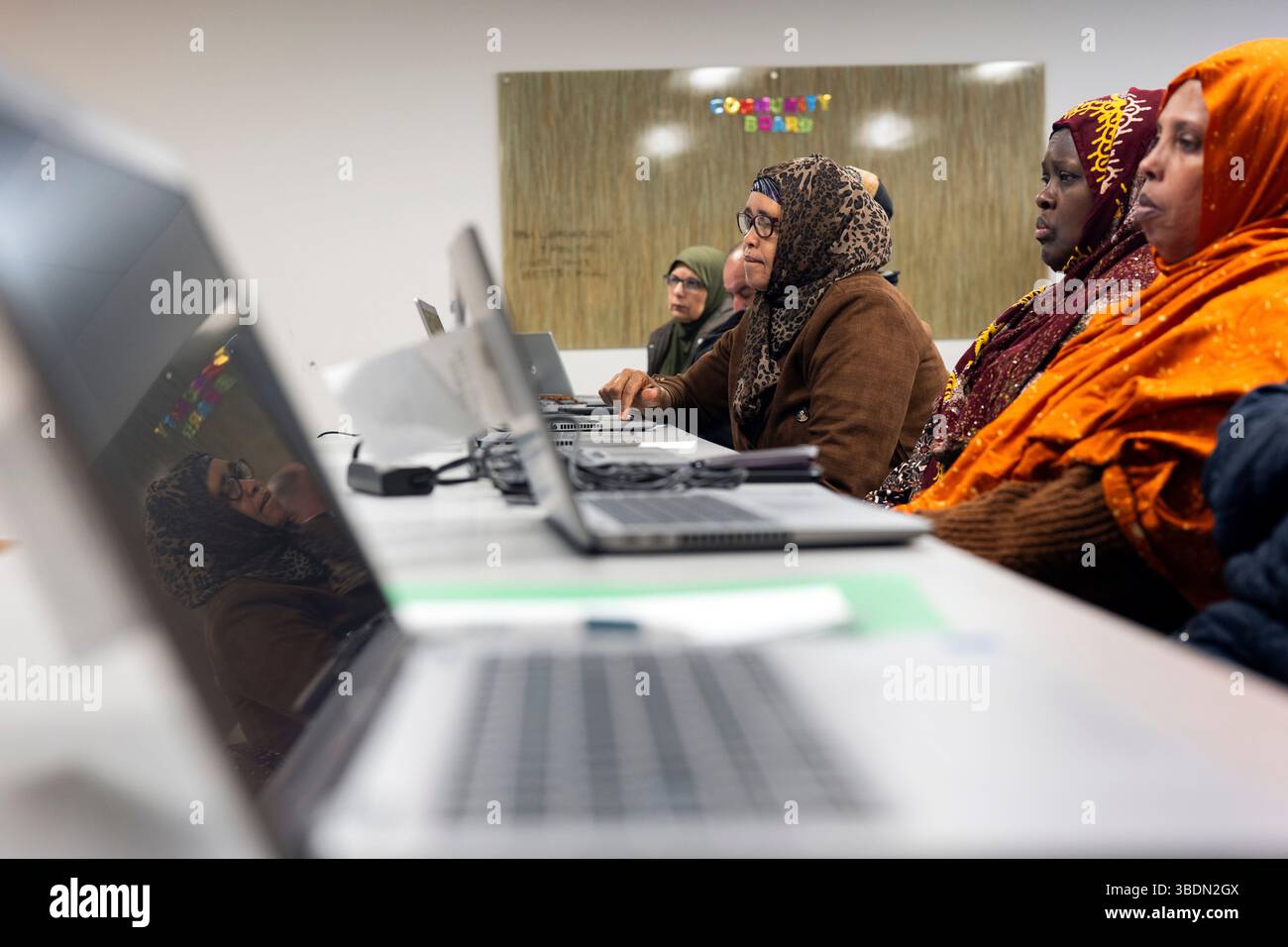Rugaya Ismail, center, is reflected in a computer screen during a ...