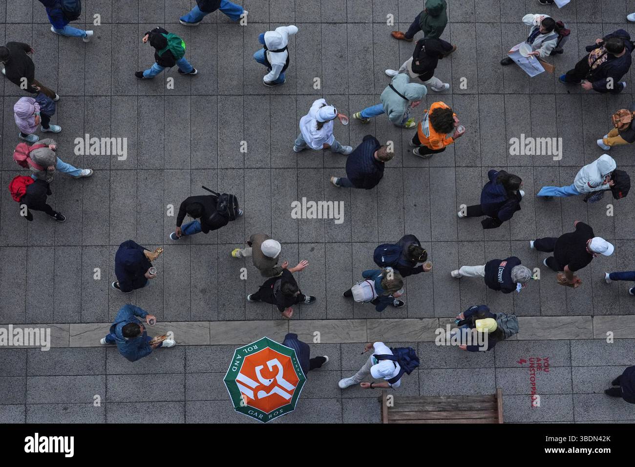 Spectators walk under the rain at the French Tennis Open at the Roland ...