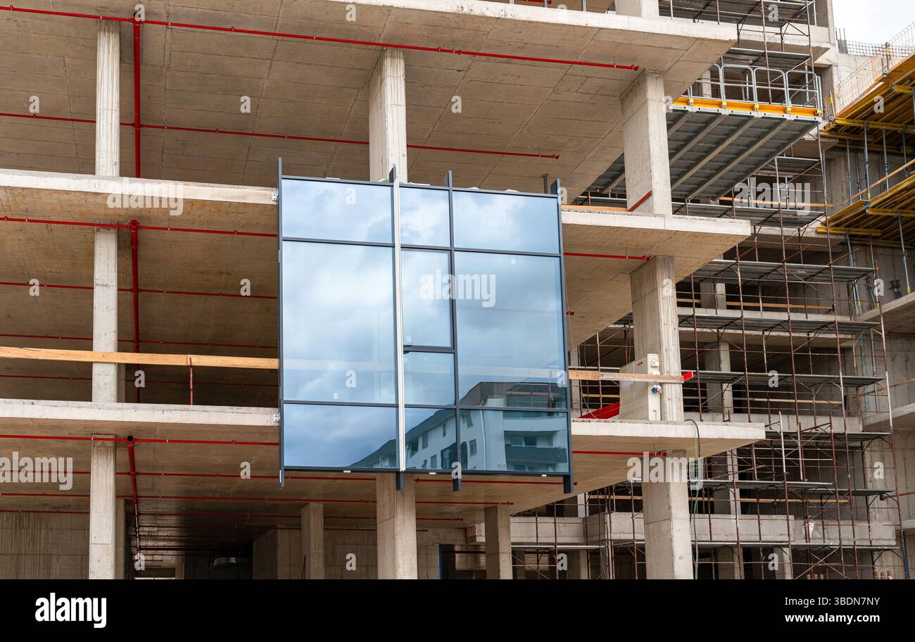 Installation of unitized glass curtain wall panel on modern concrete ...