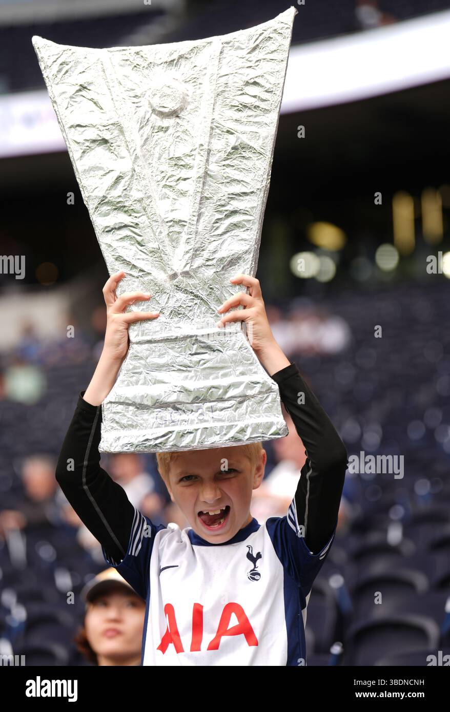 A Tottenham Hotspur fan in the stands with a homemade tin foil trophy ...