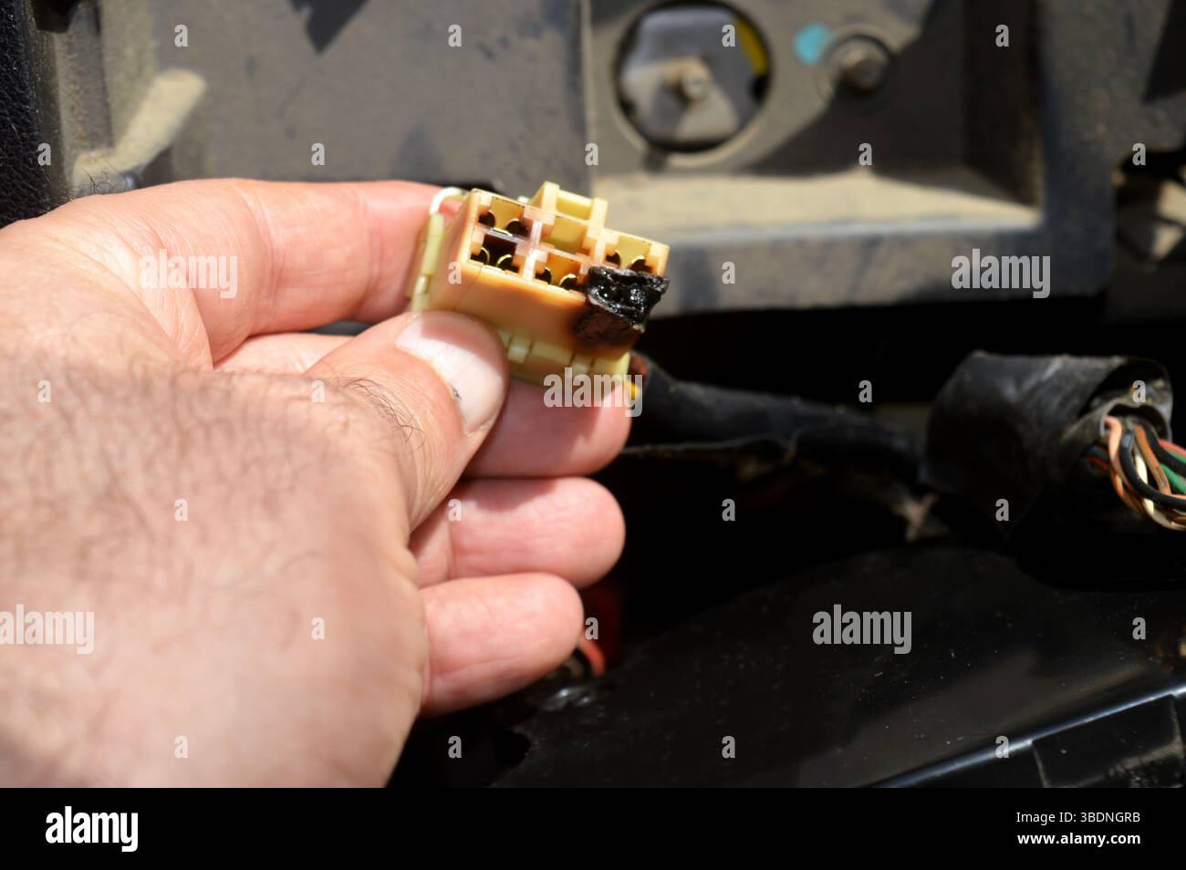 A burnt plug in the car electricity system connected to the wires that ...