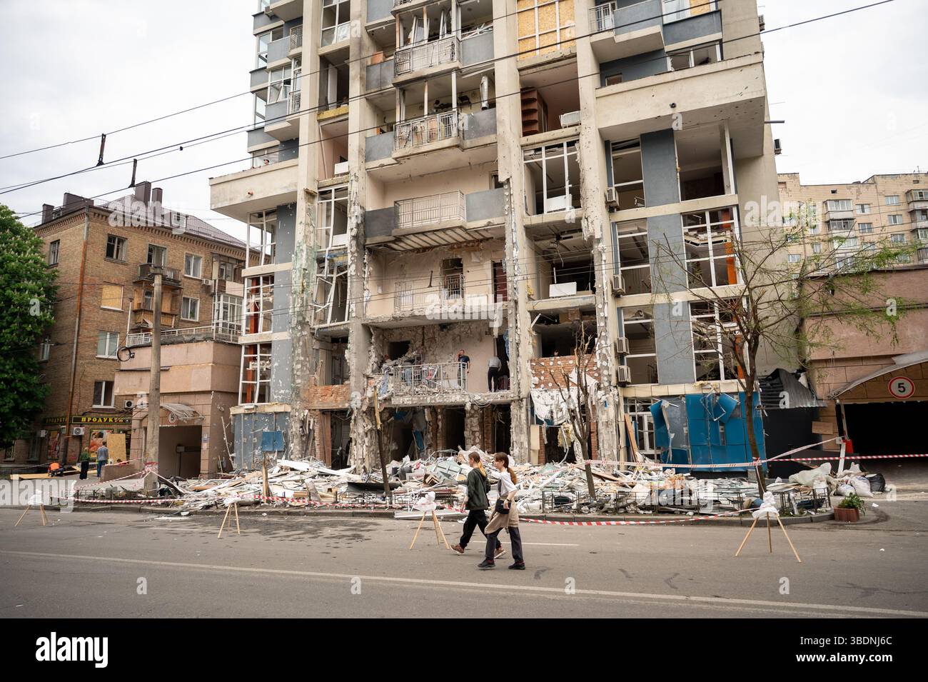 Construction workers clear damage from a combined drone and missile ...