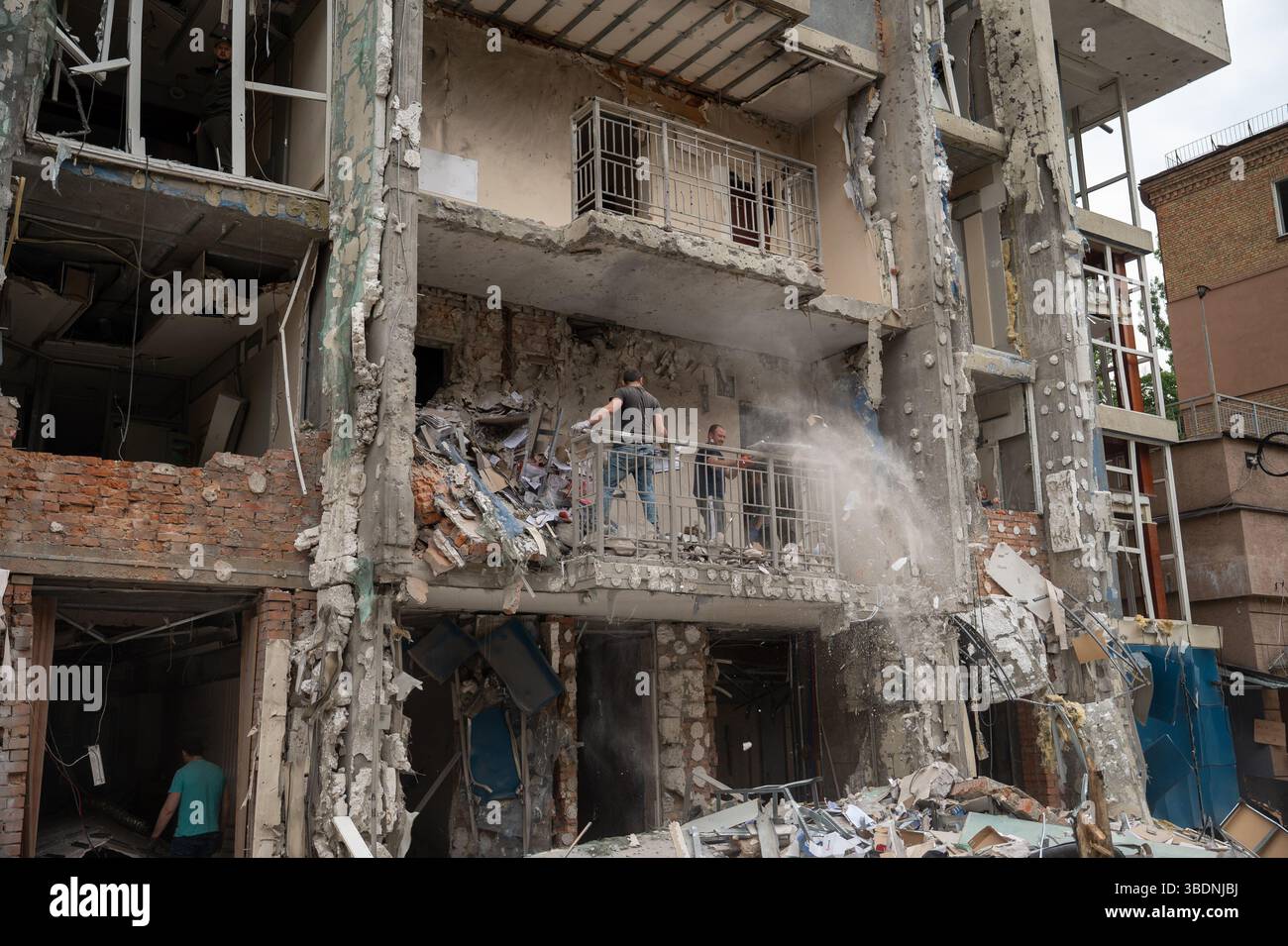 Construction workers clear damage from a combined drone and missile ...