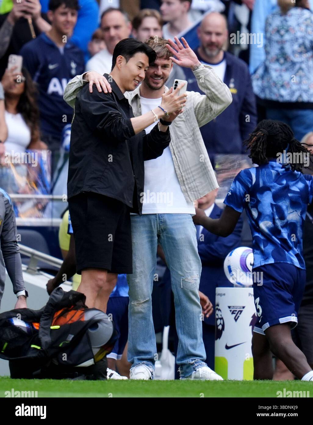 Tottenham Hotspur's Son Heung-Min (left) and James Maddison pitch side ...