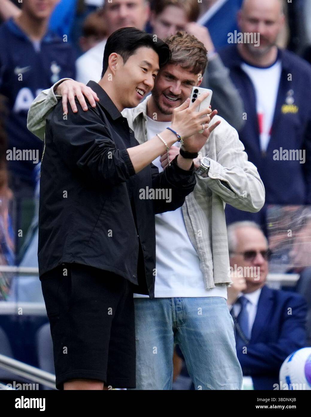 Tottenham Hotspur's Son Heung-Min (left) and James Maddison pitch side ...