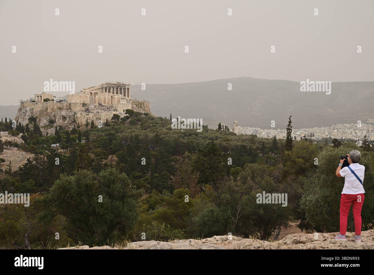 African dust covers Athens A tourist takes pictures of the Acropolis ...