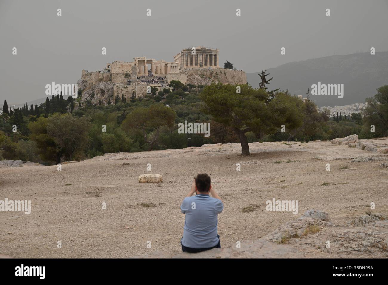 African dust covers Athens A tourist takes pictures of the Acropolis ...