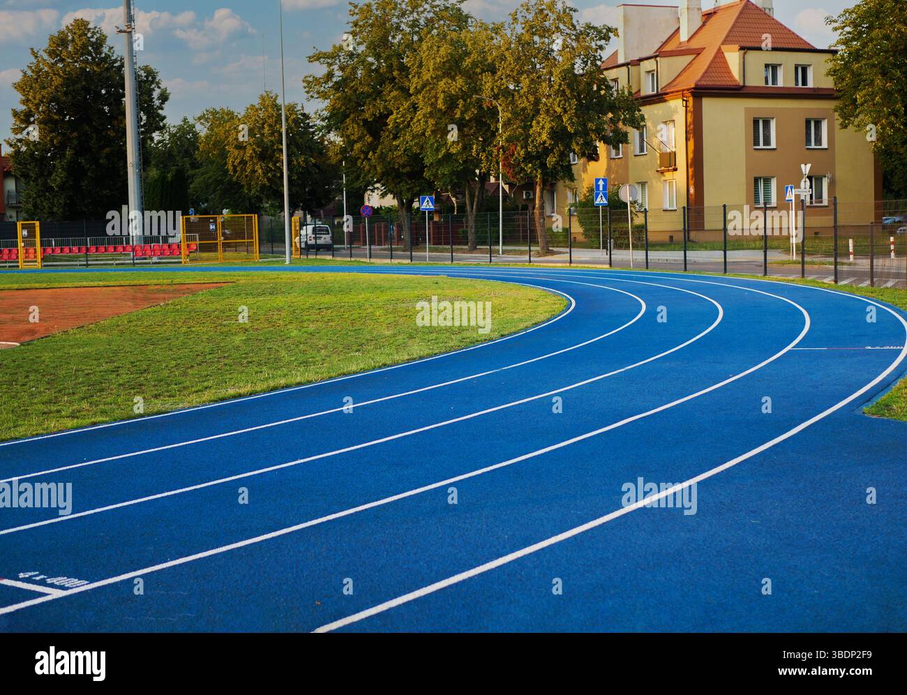 Modern soccer stadium with green turf and blue jogging track in a ...