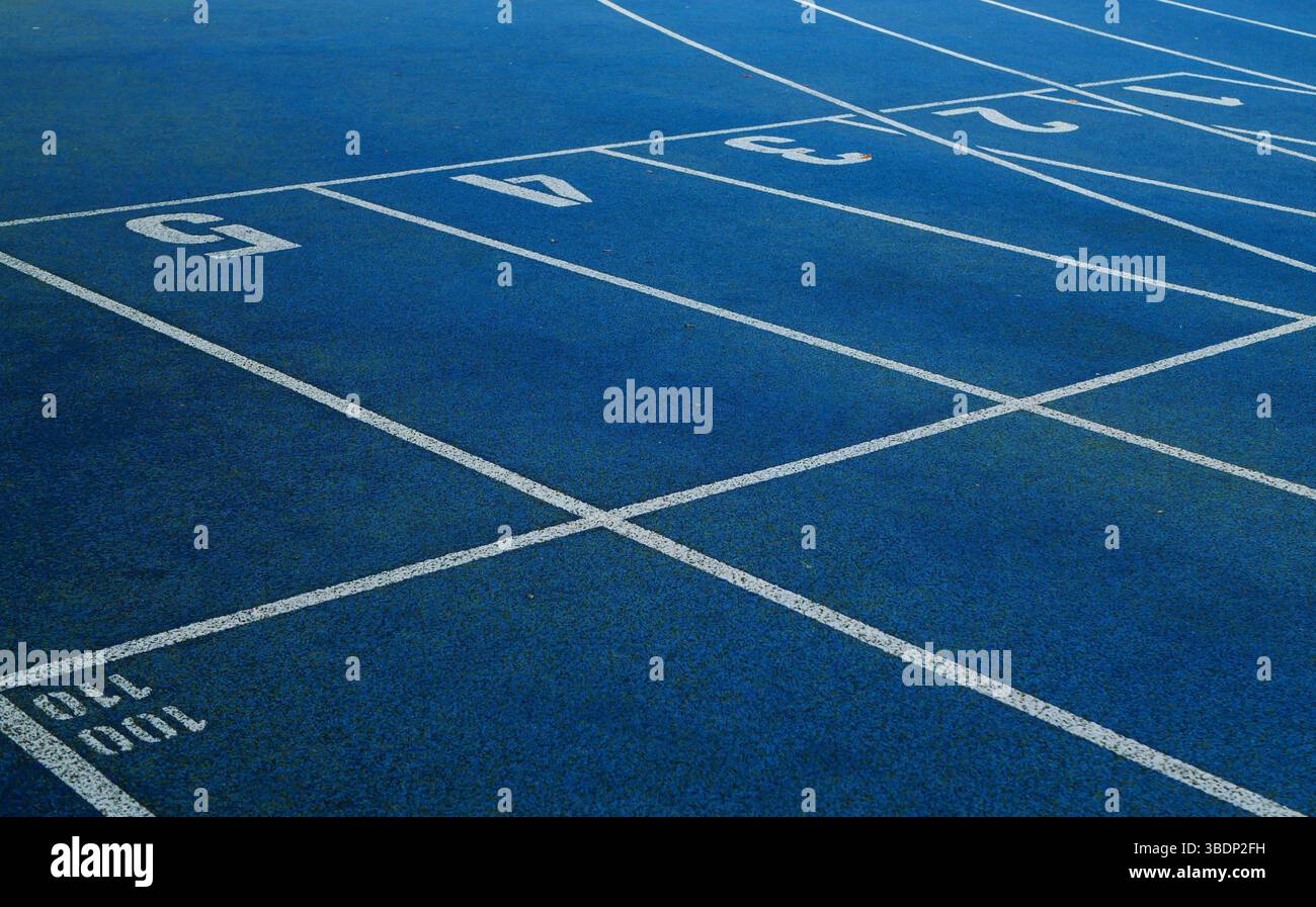 Curved blue running track with white lane markings in an outdoor sports ...