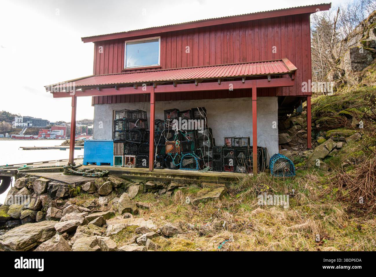 Fishing shack with stacked lobster traps by water Stock Photo - Alamy