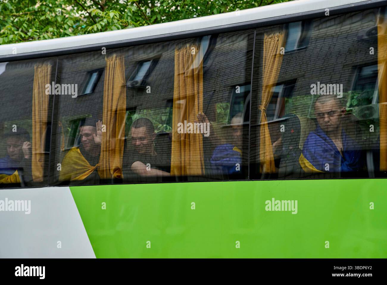 Ukrainian soldiers look out of the bus windows as they return from ...
