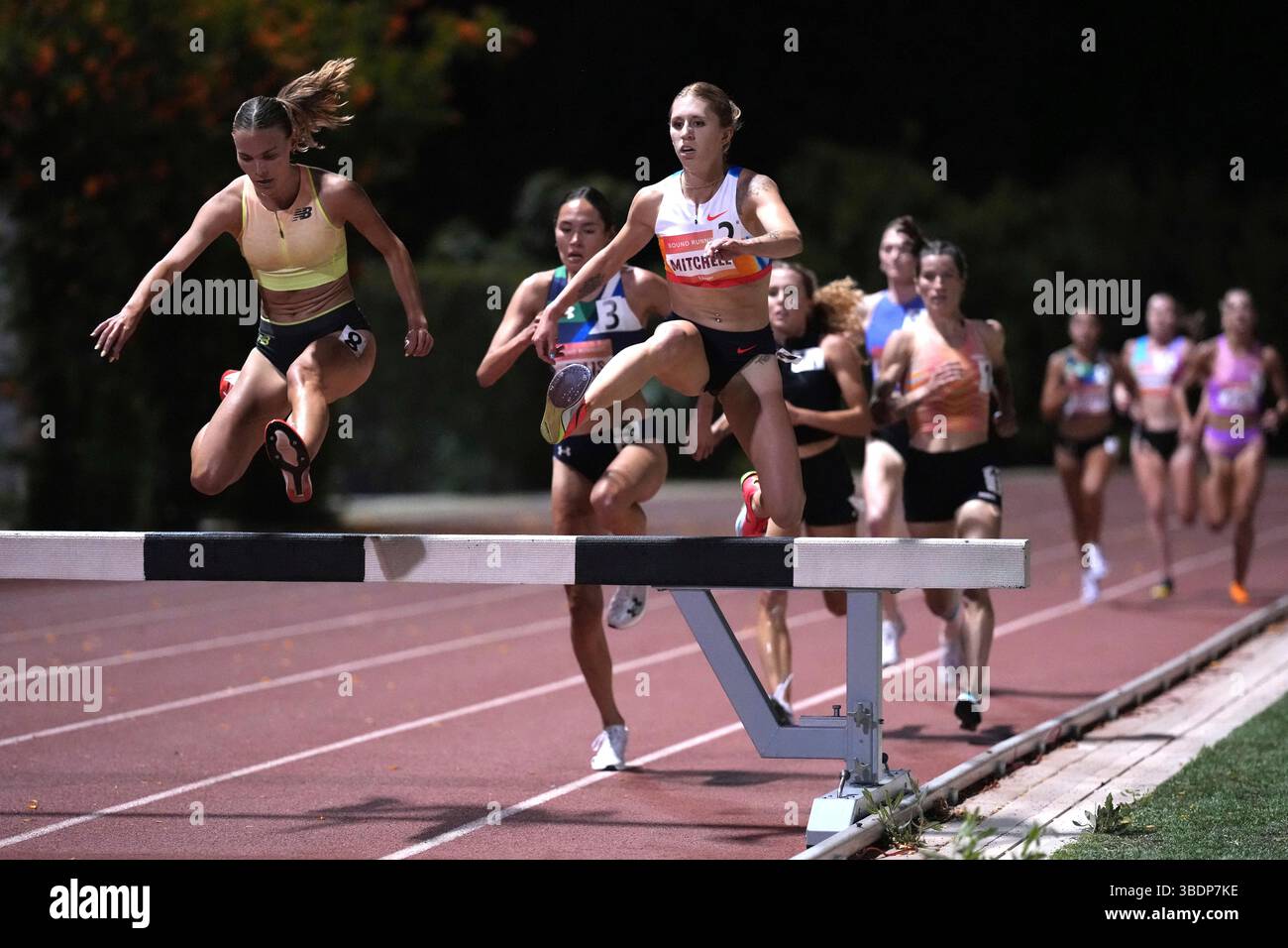 Elise Crawford (GBR), left, and Kaylee Mitchell (GER) hurdle a barrier ...
