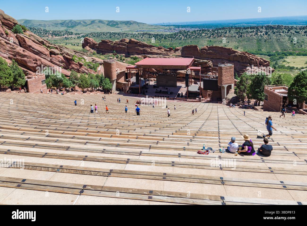 Visitors sit looking down onto stage from near the top of expansive Red ...