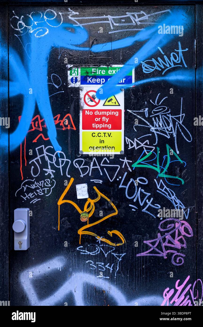 Graffiti on a fire exit door on a city street, UK Stock Photo - Alamy